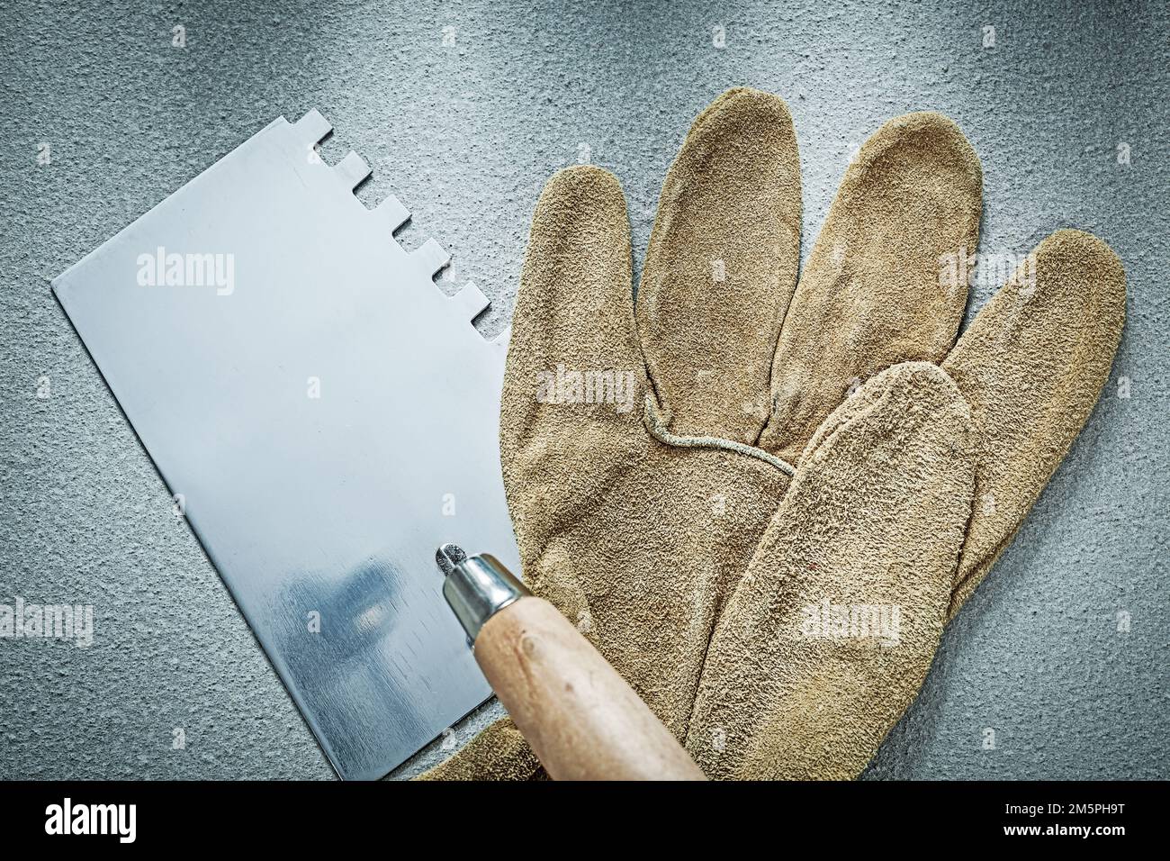 Bricklaying trowel working gloves on concrete background construction ...