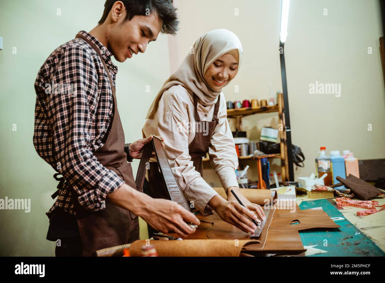 male craftsman and female craftsman in hijab work together Stock Photo ...