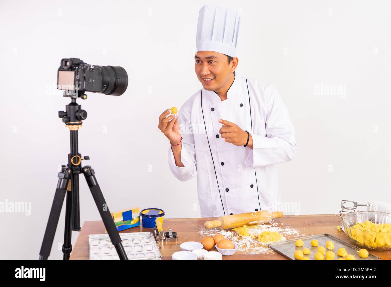 chef wearing a chef jacket making a tutorial video Stock Photo - Alamy