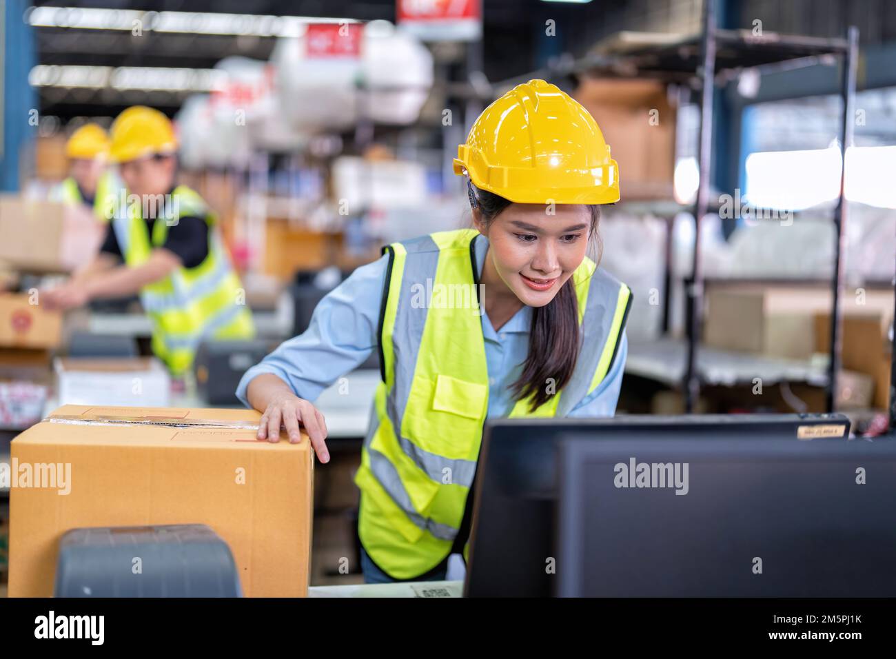 Worker working in the large depot storage warehouse happy smiling ...