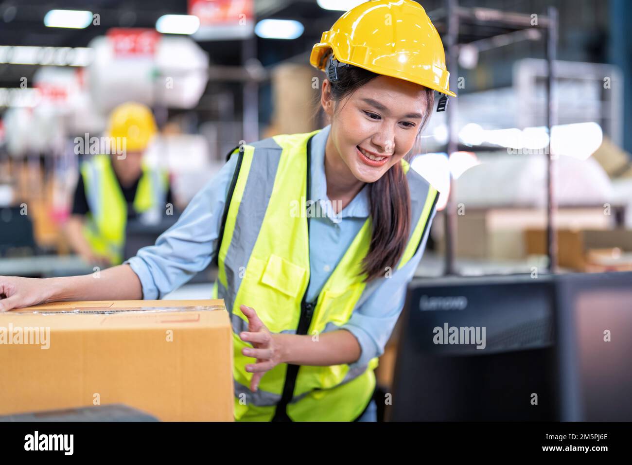 Worker working in the large depot storage warehouse happy smiling ...