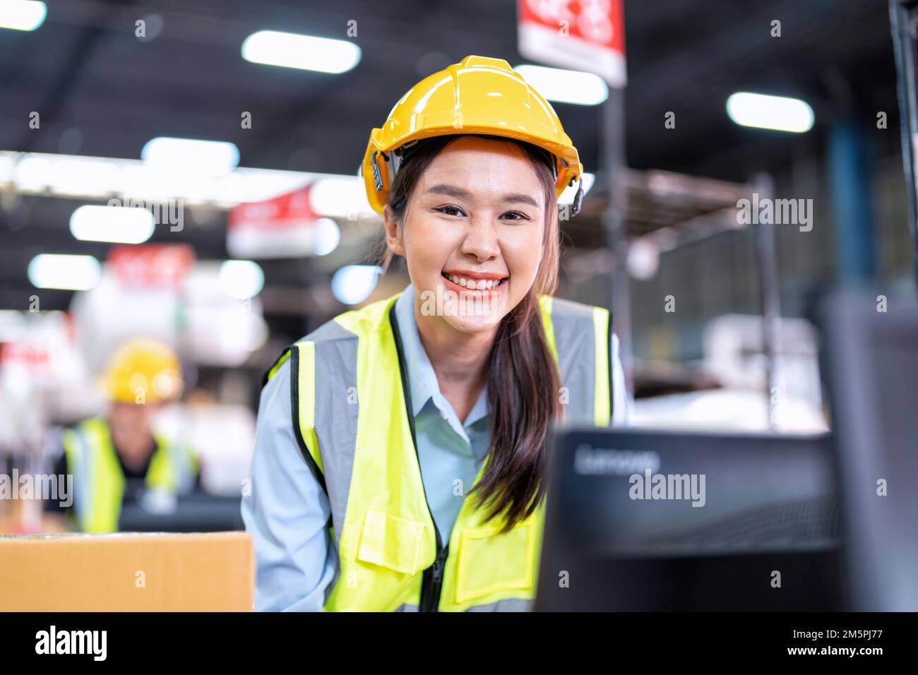 Worker working in the large depot storage warehouse happy smiling ...