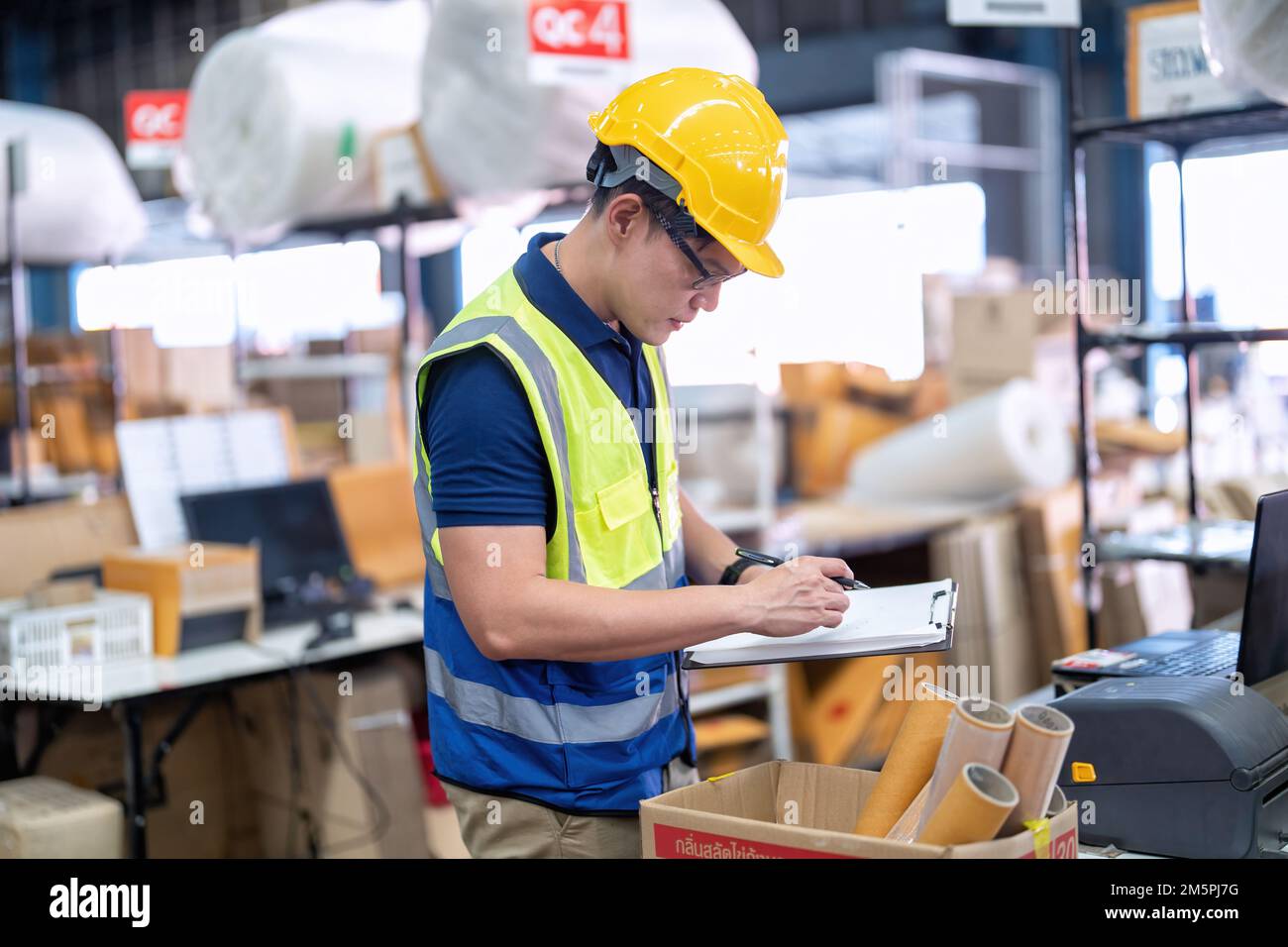 Worker working in large depot storage warehouse hold check list for ...