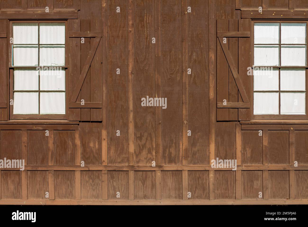 The exterior design of a wooden barn with two windows on a sunny day ...