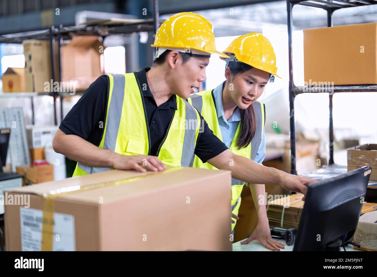 Staff working in large depot storage warehouse trainee check packing ...