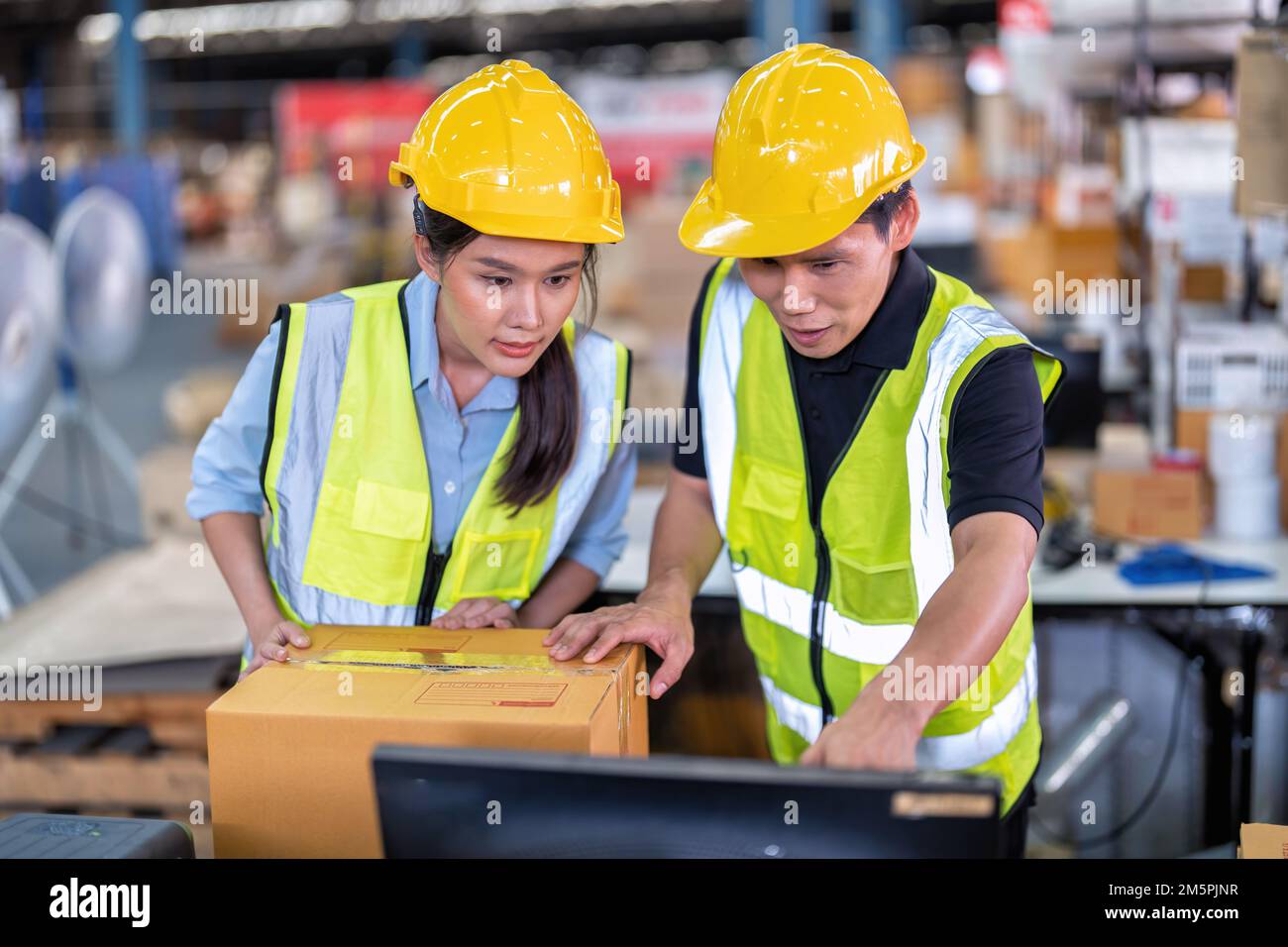Staff working in large depot storage warehouse trainee check packing ...
