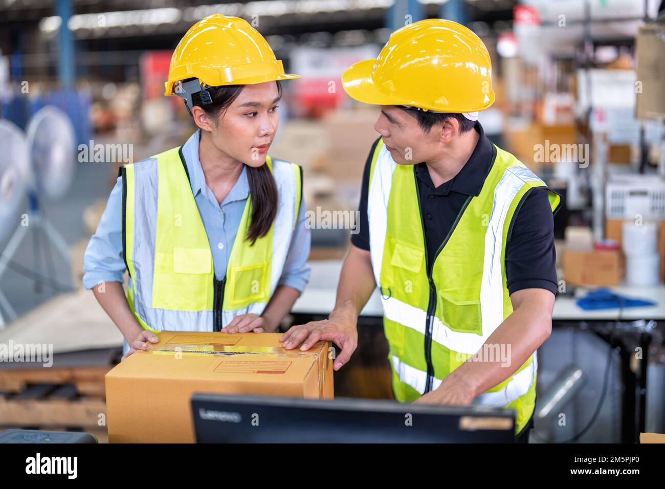 Staff working in large depot storage warehouse trainee check packing ...