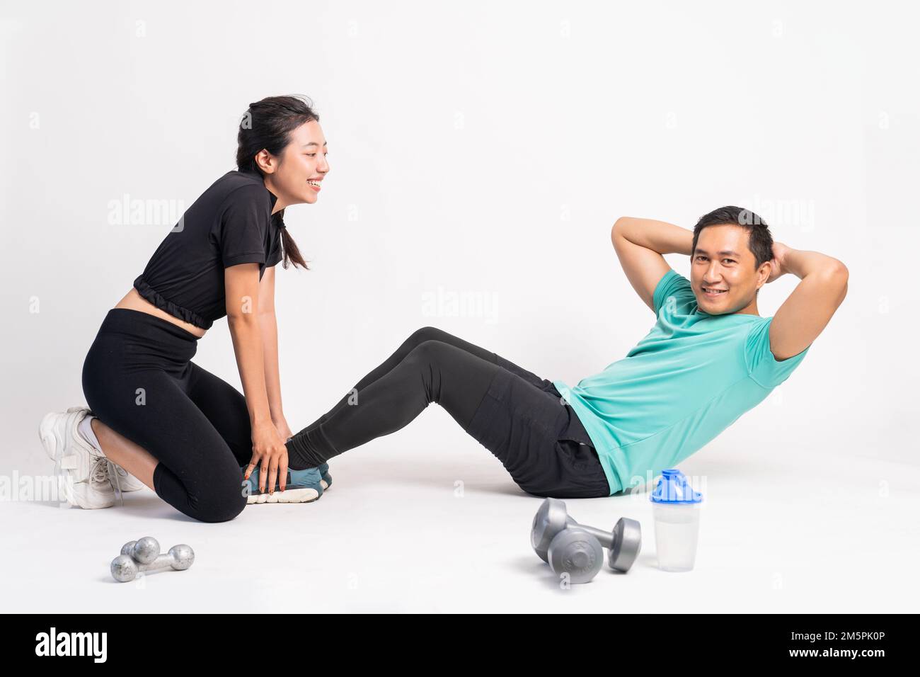 smiling man doing sit ups with woman to hold legs Stock Photo - Alamy