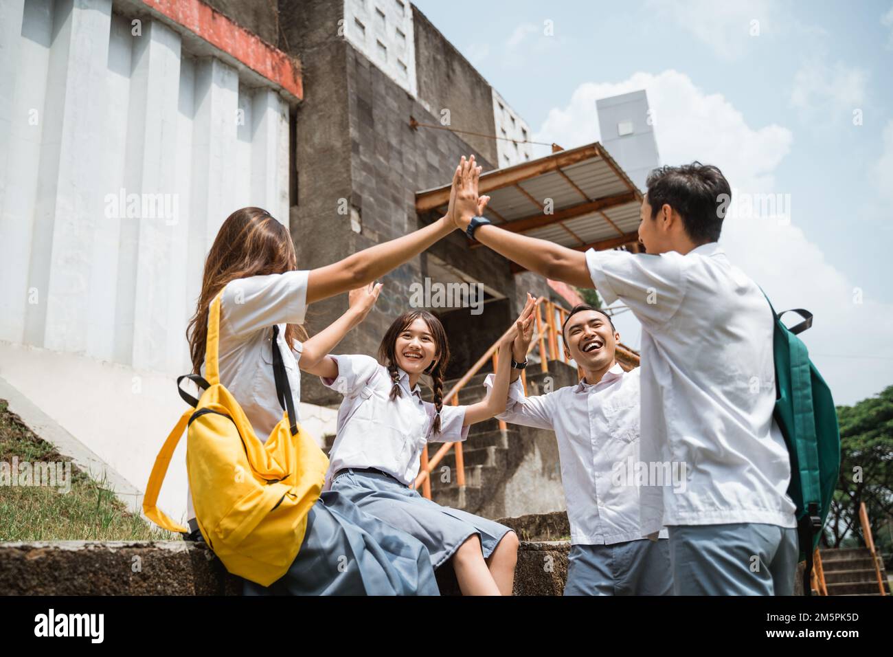 High school students put their hands together as unity Stock Photo - Alamy