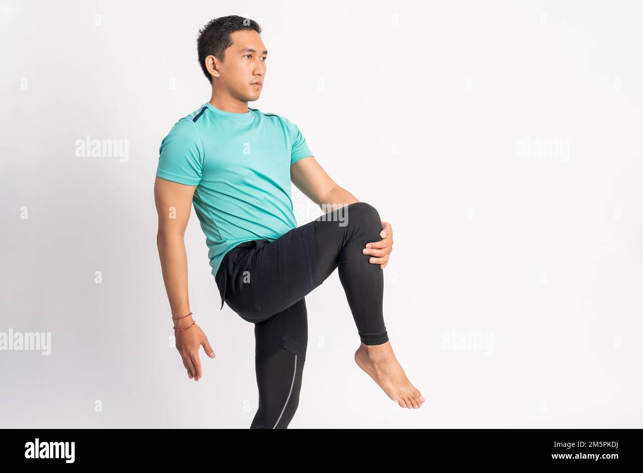 asian man standing stretching legs by holding one leg forward Stock ...