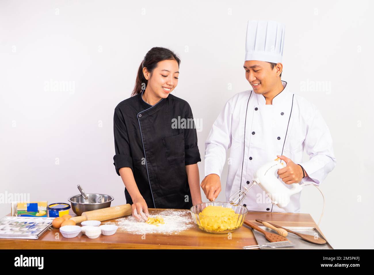 male and female chefs making cookie dough and using mixer Stock Photo ...
