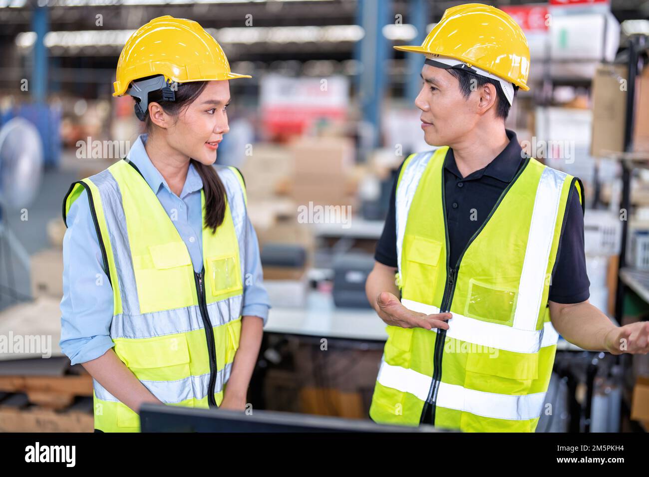 Staff working in large depot storage warehouse trainee check packing ...