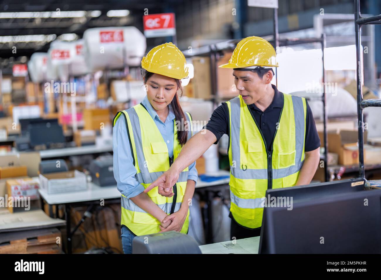 Staff working in large depot storage warehouse trainee check packing ...