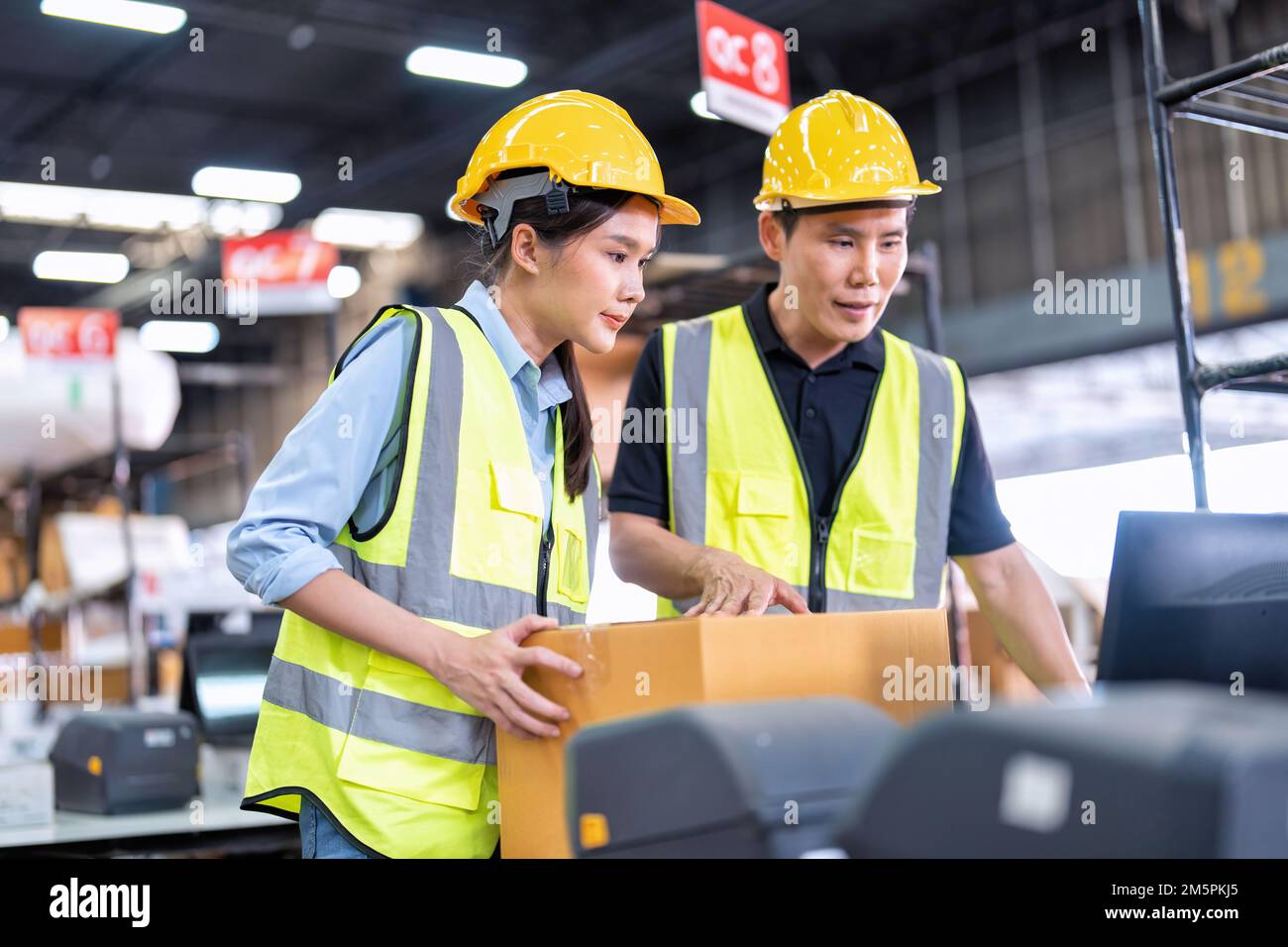 Staff working in large depot storage warehouse trainee check packing ...
