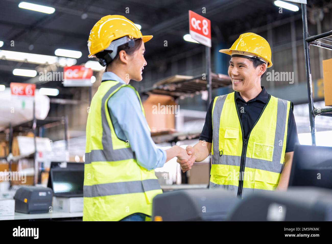 Staff working in large depot storage warehouse trainee check packing ...