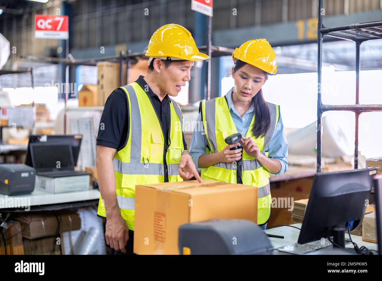 Staff working in large depot storage warehouse trainee check packing ...