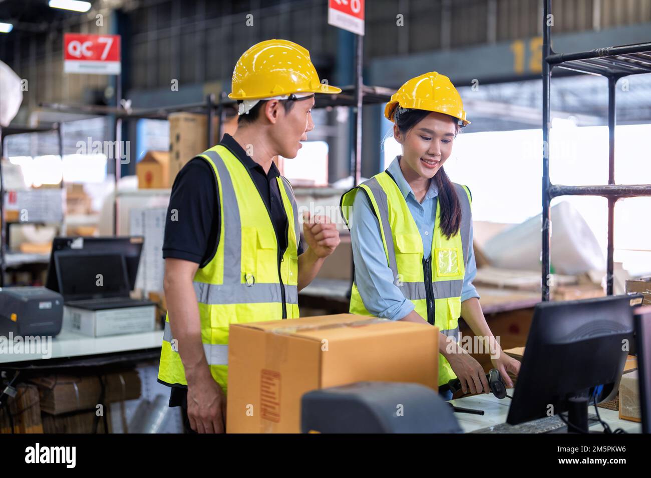 Staff working in large depot storage warehouse trainee check packing ...