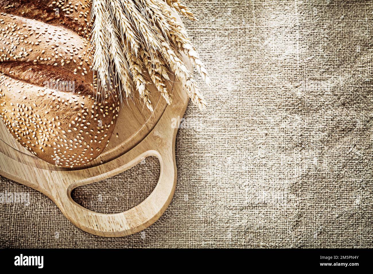 Carving board bread wheat ears on sacking background Stock Photo - Alamy