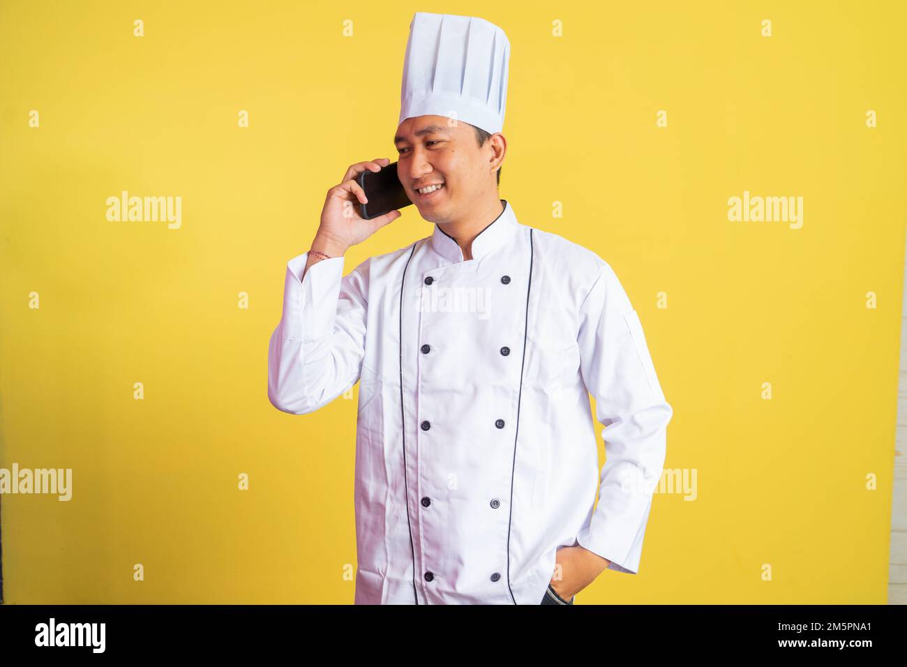 asian male chef wearing chef jacket making a phone call Stock Photo - Alamy