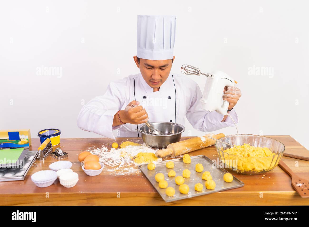 male chef using whisk in mixing bowl with mixer Stock Photo - Alamy