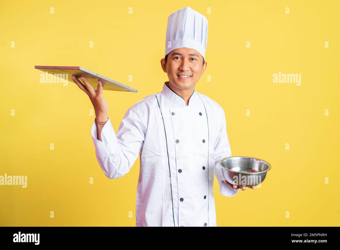handsome male chef holding bread tray with mixing bowl Stock Photo - Alamy