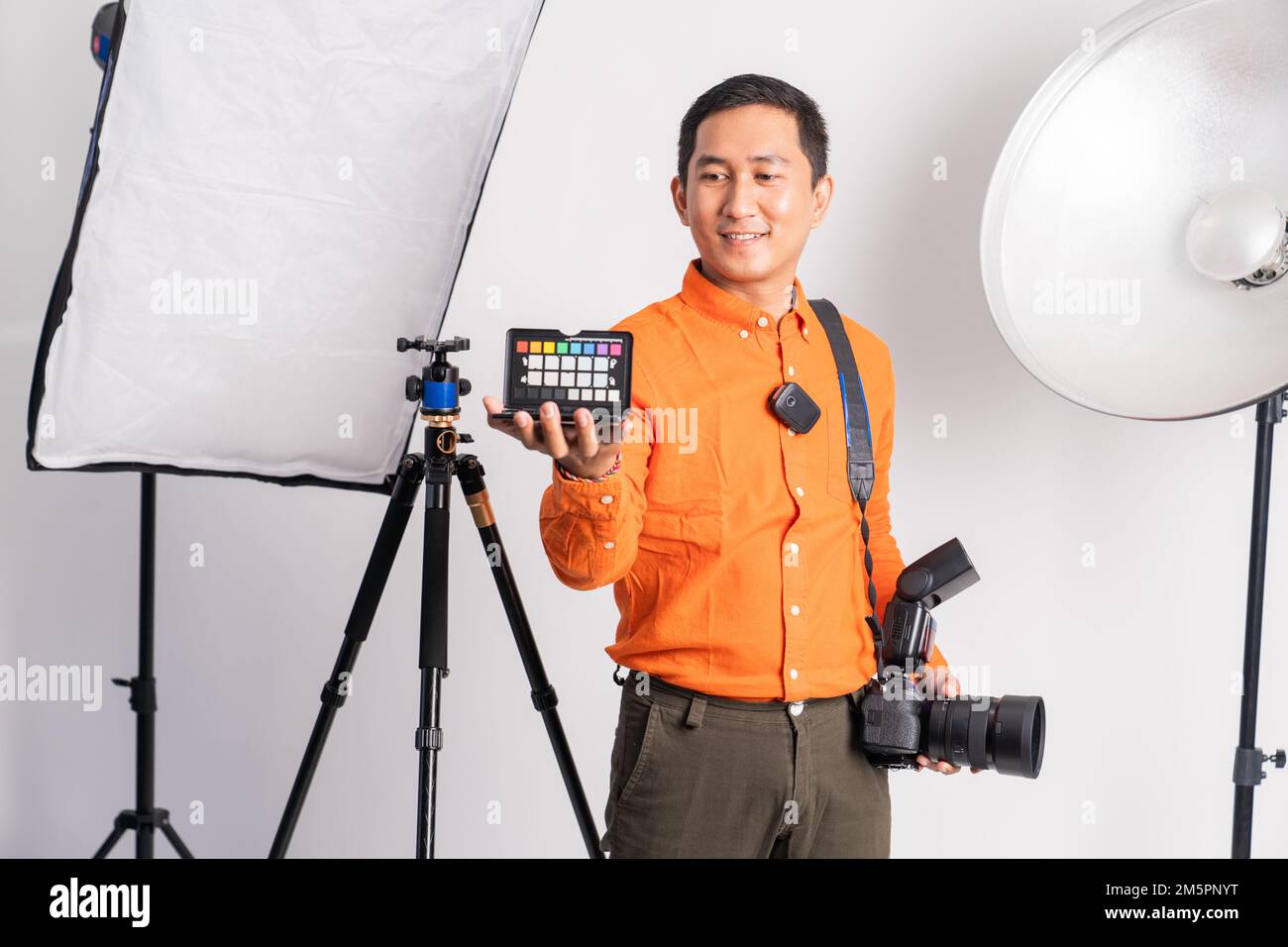 photographer holding color palette while carrying camera with lighting ...
