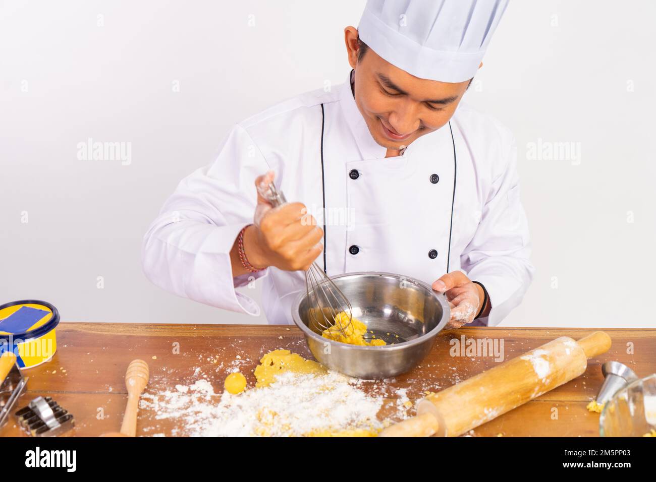 male chef using whisk in mixing bowl on table Stock Photo - Alamy
