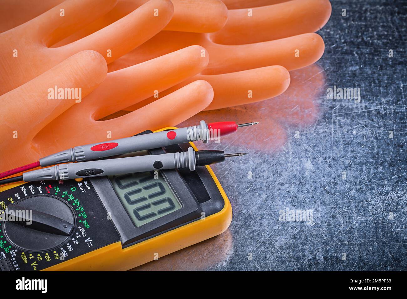 Digital electrical tester insulating rubber gloves on metallic ...
