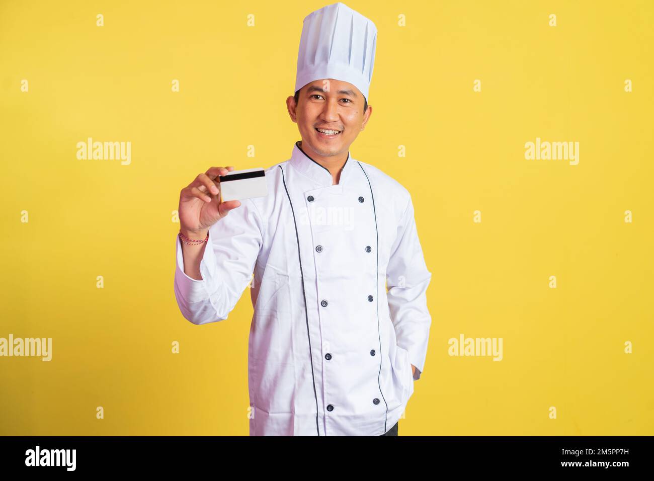 asian male chef wearing chef jacket showing credit card Stock Photo - Alamy