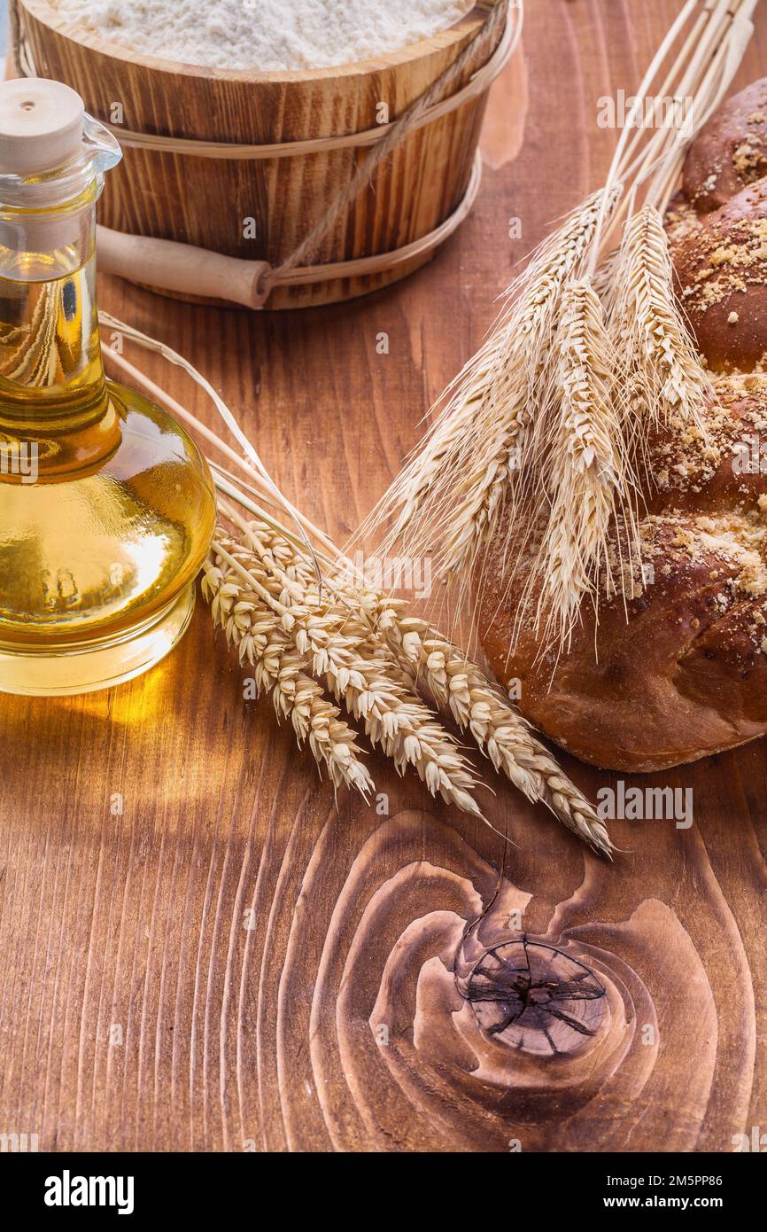 food and drink concept ears of wheat loaf of sweet bun bottle with oil ...