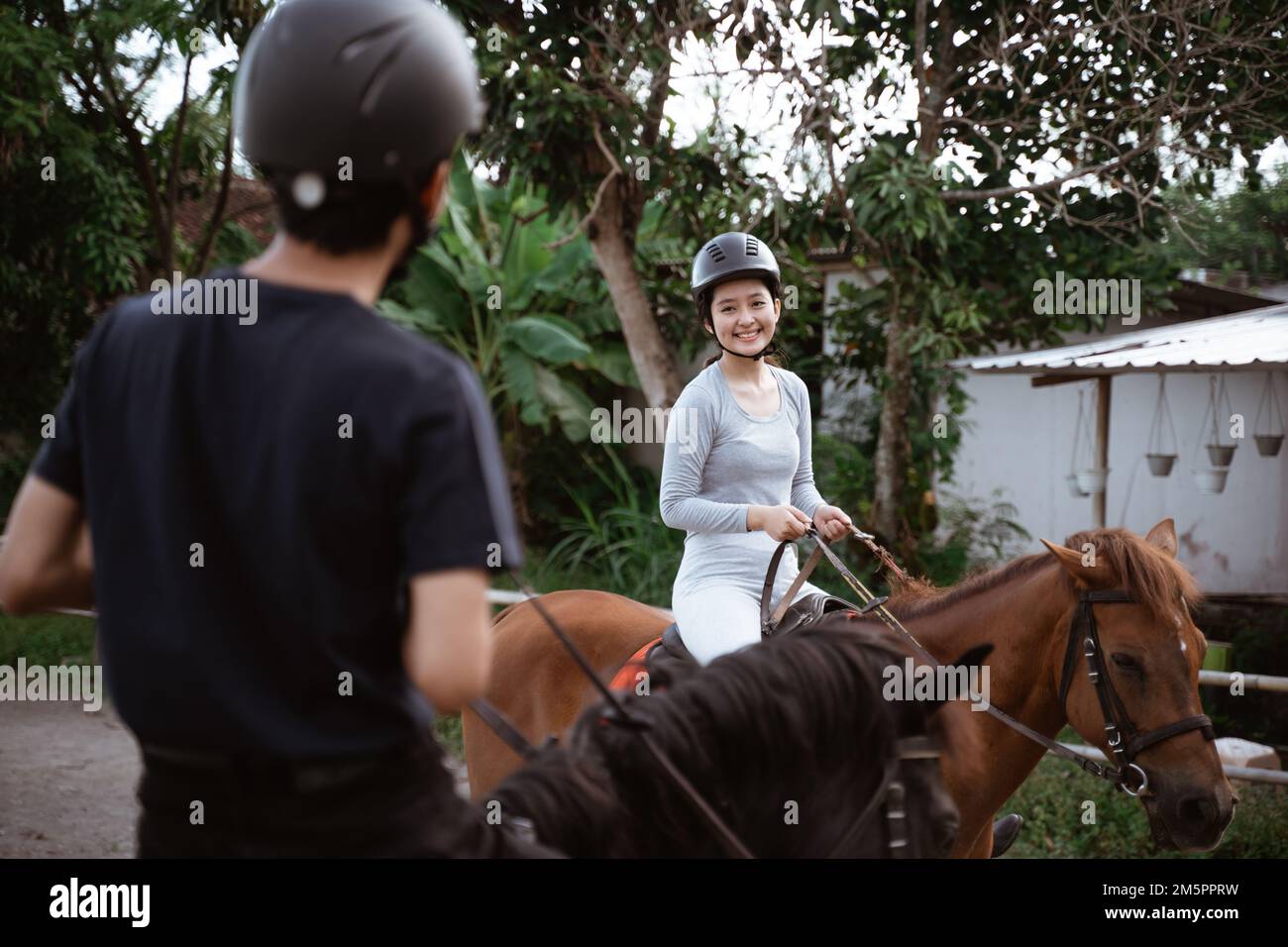 asian female equestrian meets her friend during training Stock Photo - Alamy