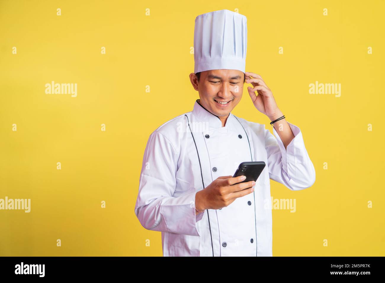 asian male chef wearing chef jacket using a smartphone Stock Photo - Alamy