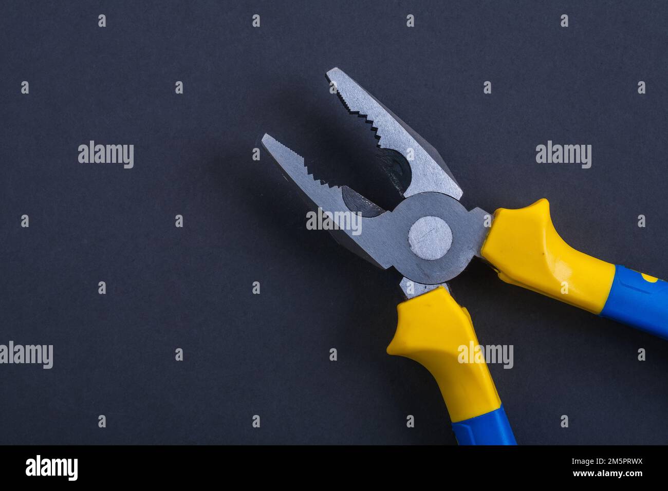 opened pliers cose up on black background Stock Photo - Alamy