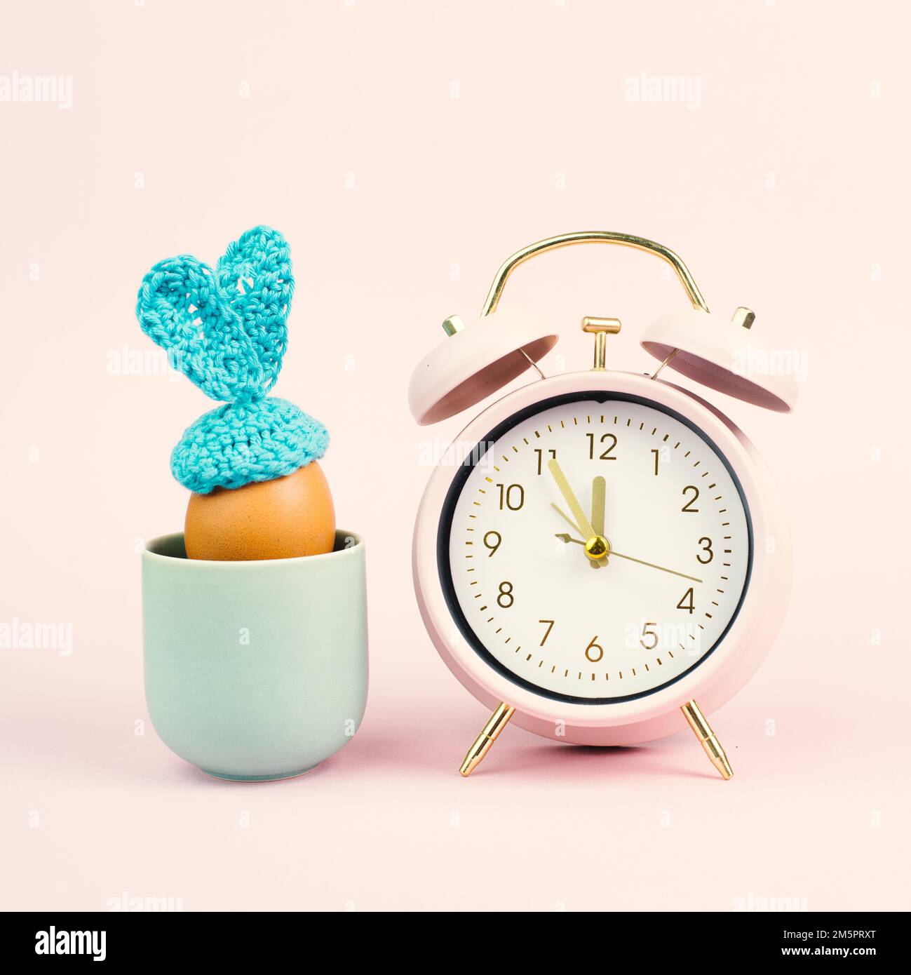 Cute easter bunny or rabbit in a cup with an alarm clock, spring ...