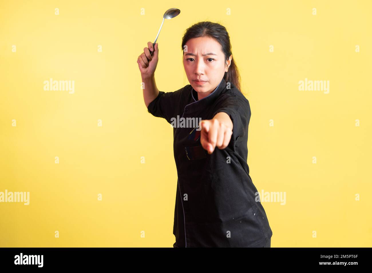 angry female chef with finger pointing and holding ladle Stock Photo ...