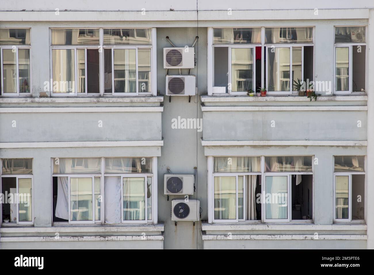 A building with open windows and air conditioners Stock Photo - Alamy