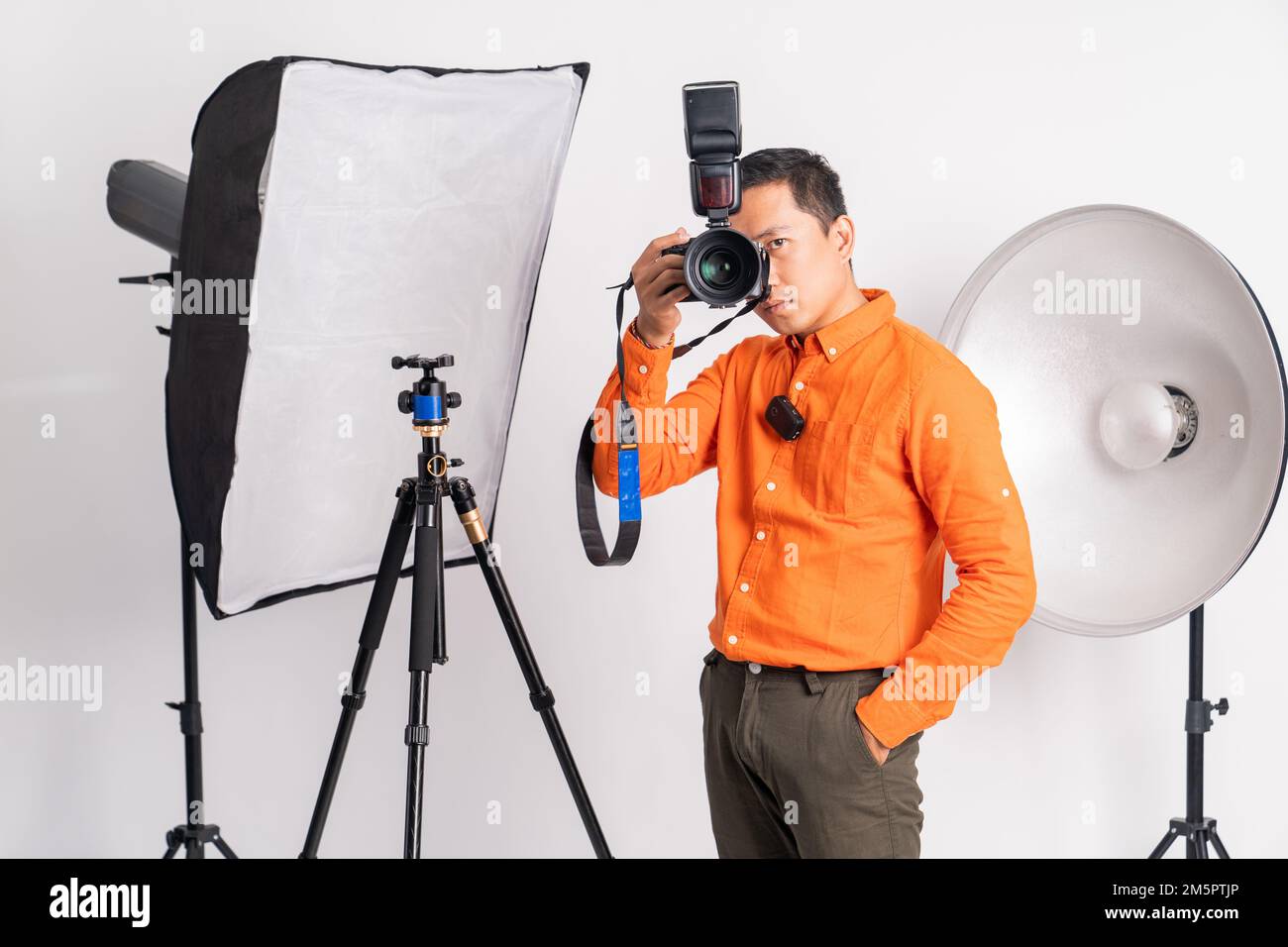man using camera to take photo when hands in pocket Stock Photo - Alamy