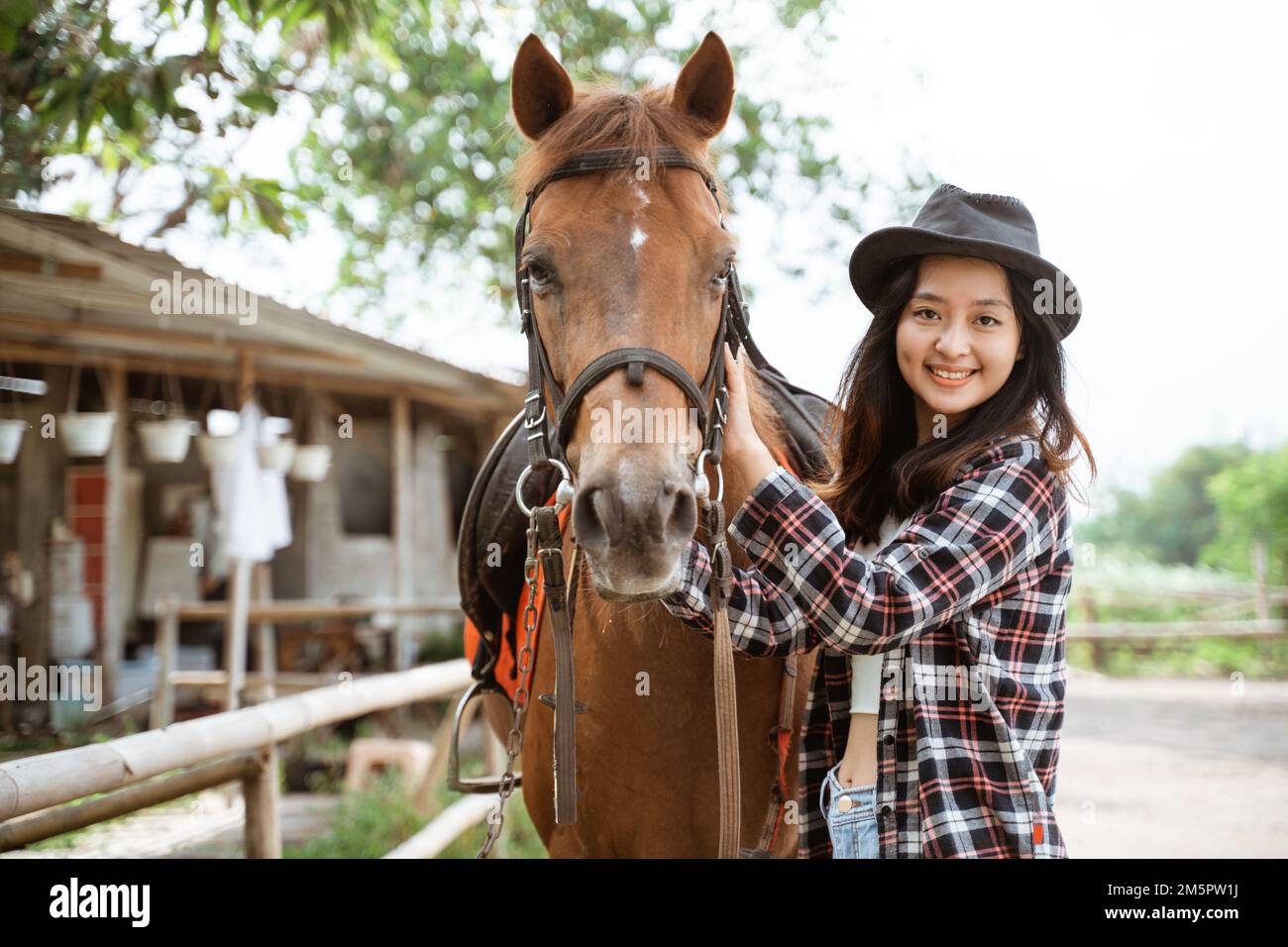 beautiful asian cowboy girl standing beside horse on outdoor background ...