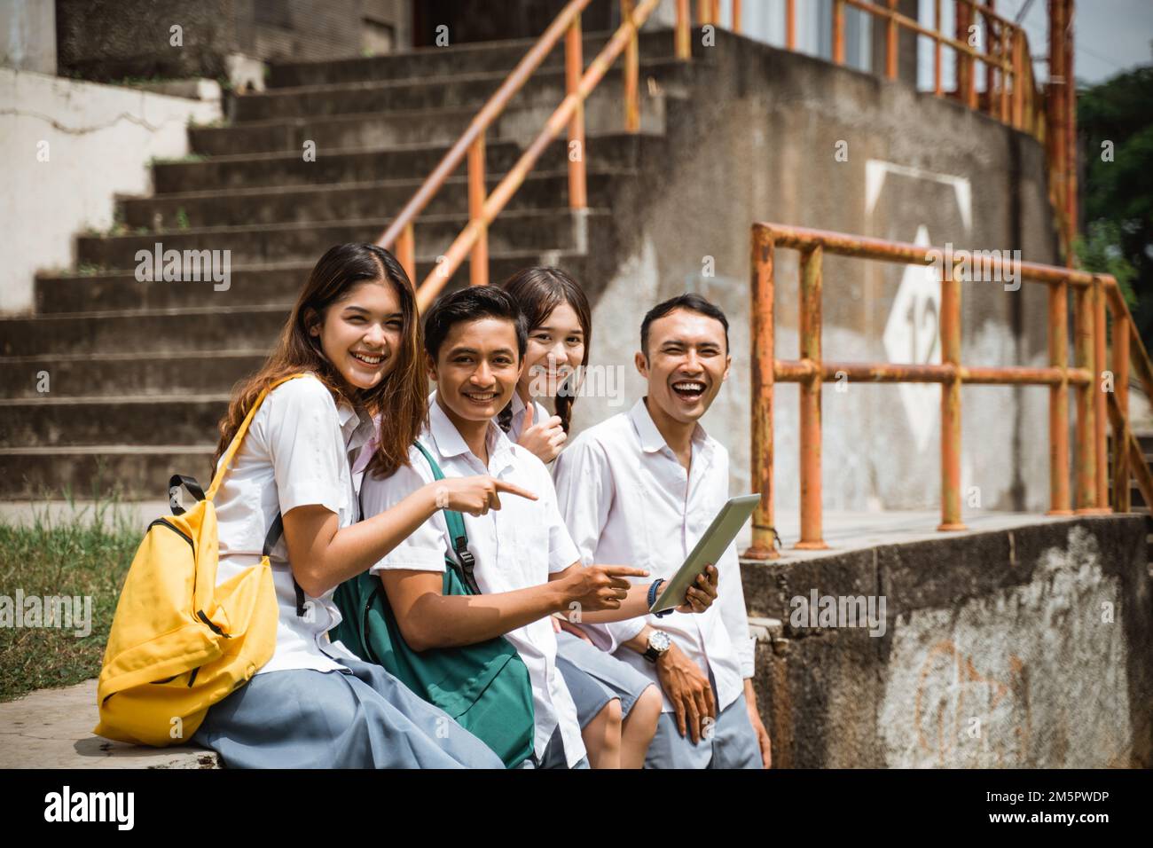 High school student using tablet with pointing looking at camera Stock ...