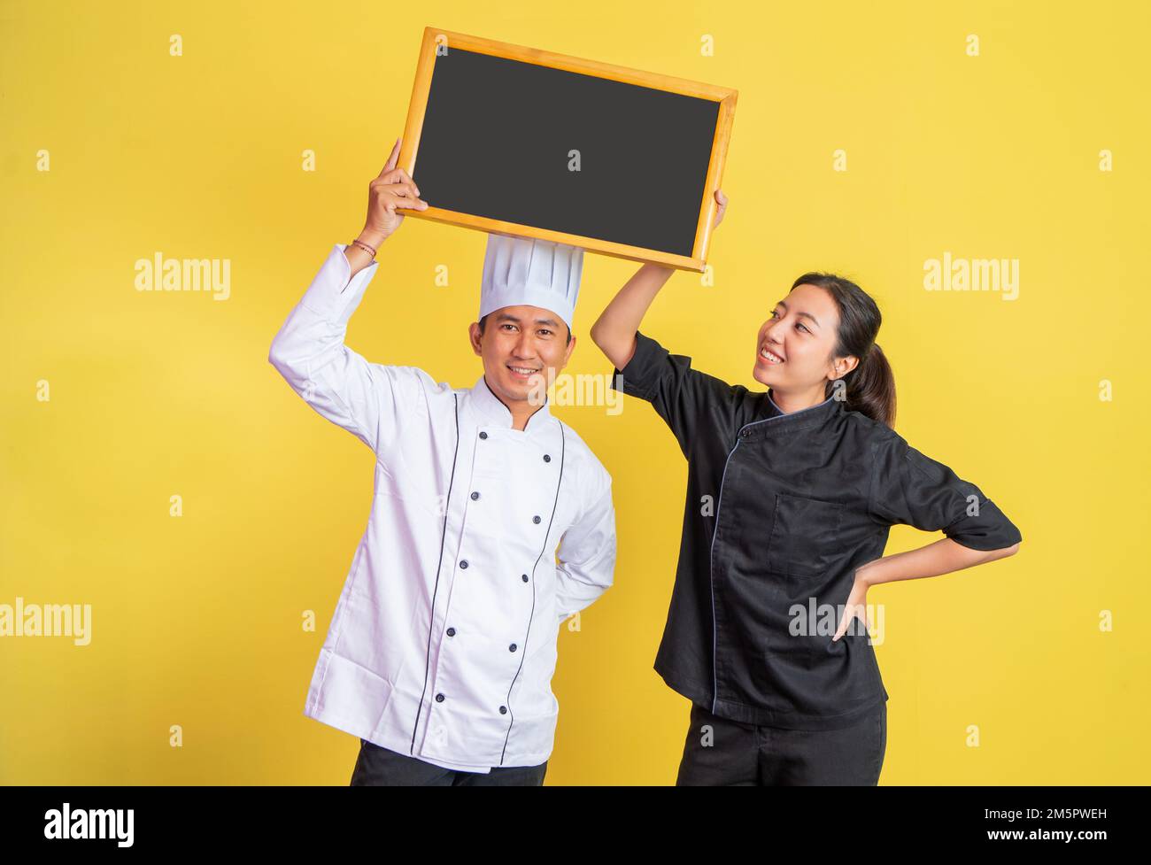 two asian chefs lifting and showing blank blackboard Stock Photo - Alamy