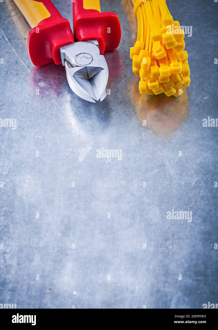 Sharp wire-cutter plastic cable ties on metallic background ...