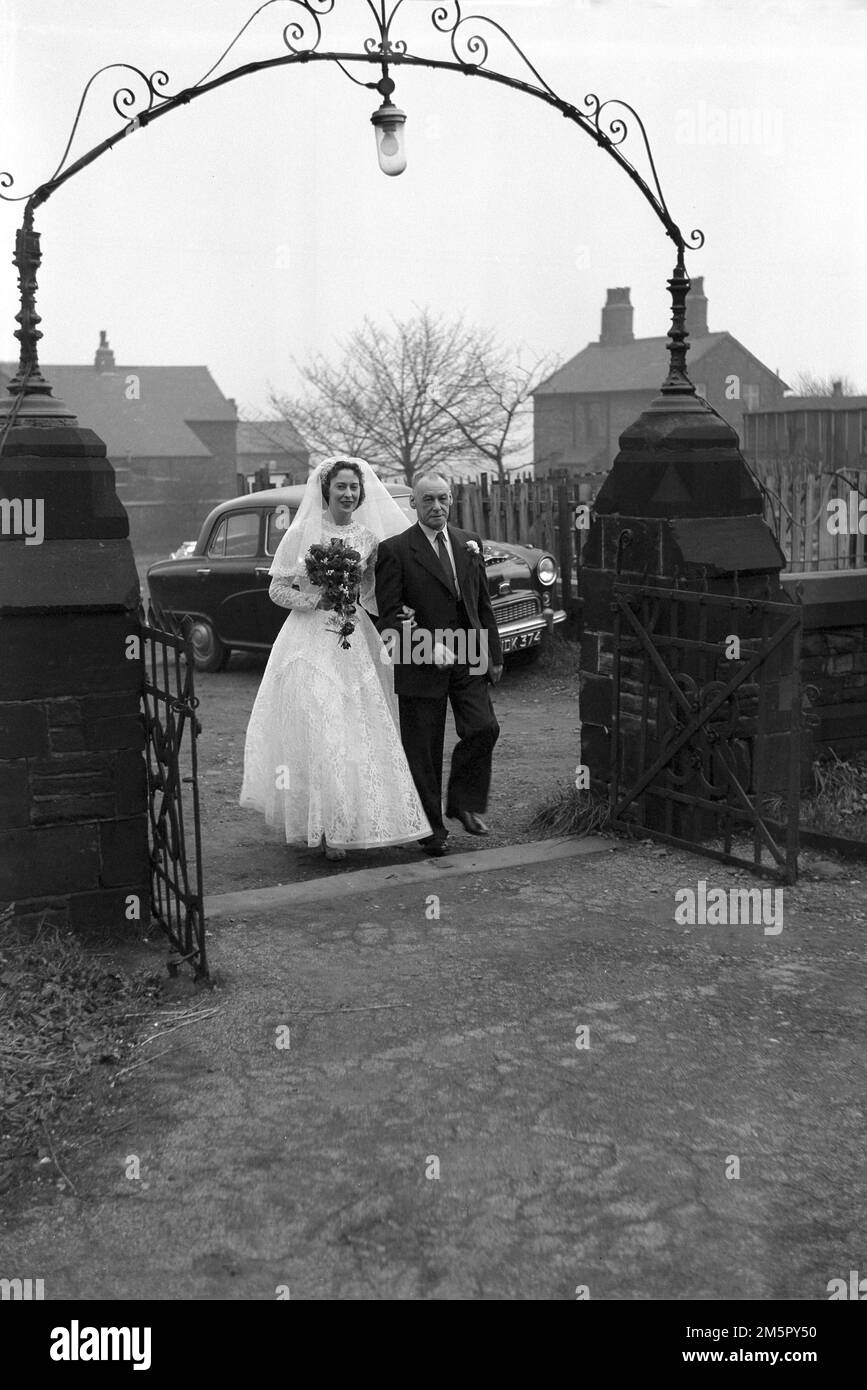 1950s, historical, a bride arrving with her father at the entrance to ...
