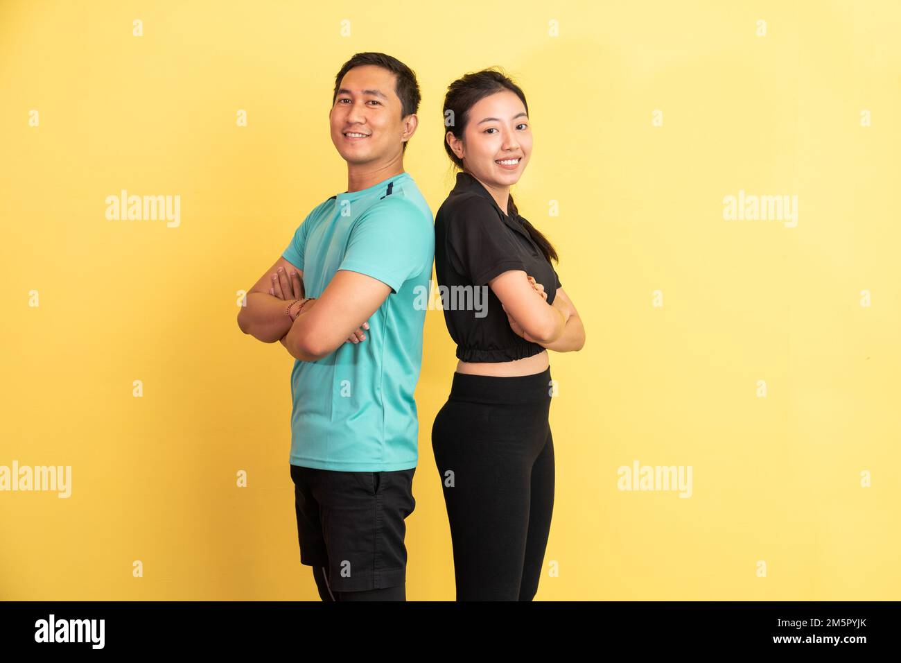 asian man and woman smiling standing back to back Stock Photo - Alamy