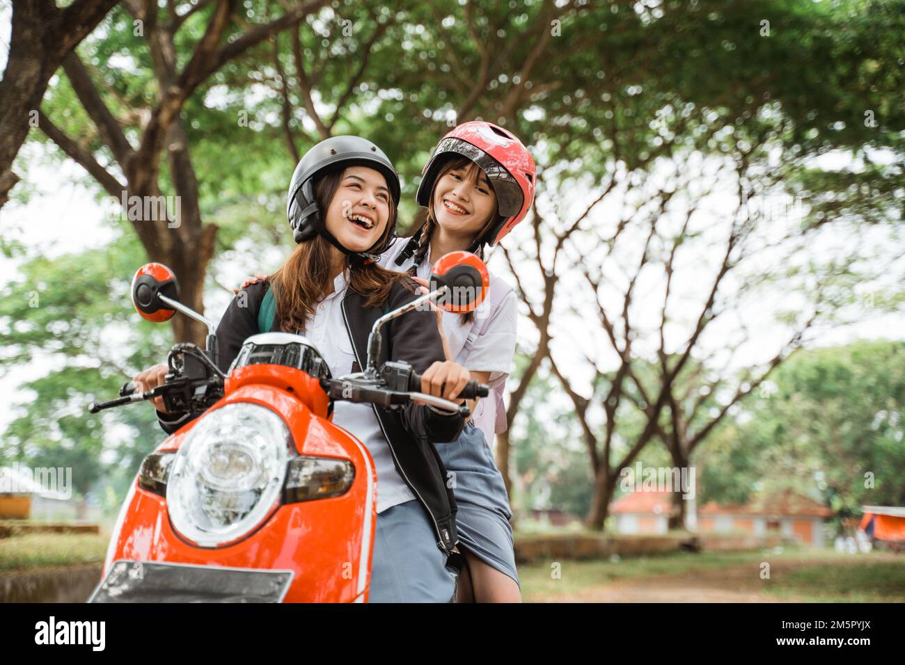 Two high school student girls enjoying a motorcycle ride together Stock ...