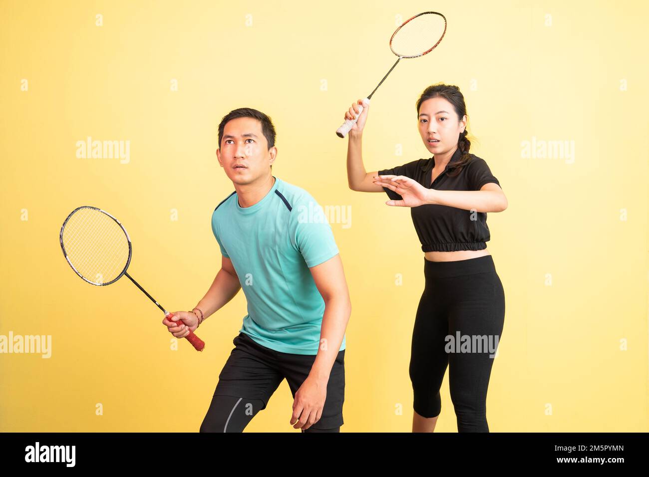 asian man and woman holding racket in ready for shuttle Stock Photo - Alamy