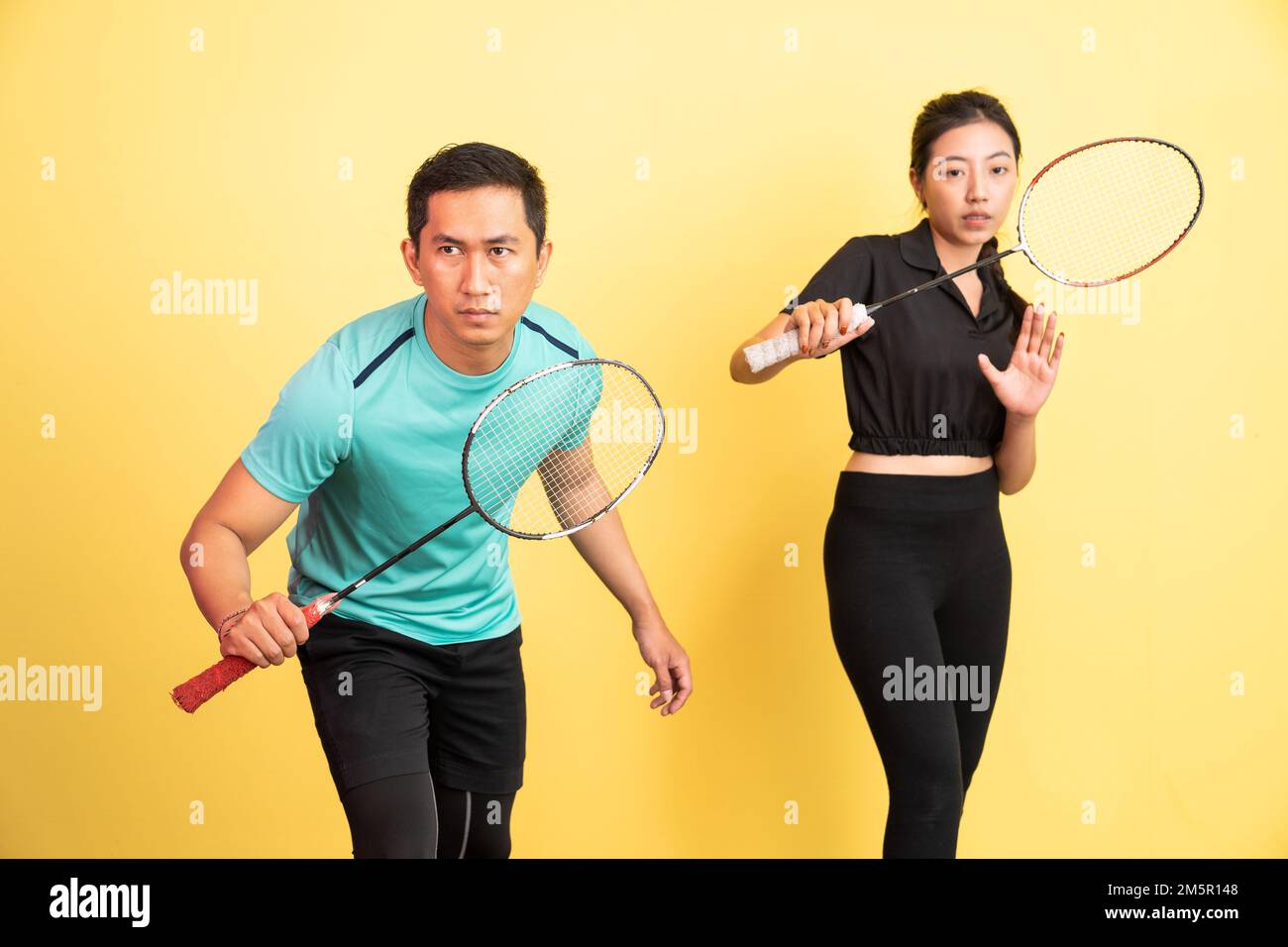 asian man and woman standing ready to hold racket Stock Photo - Alamy