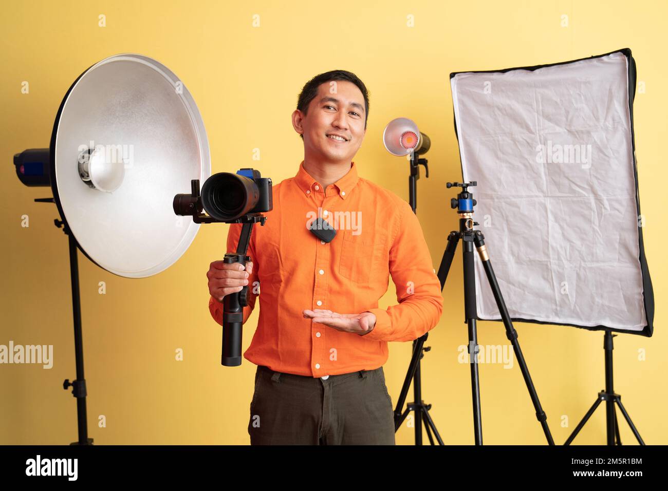 vlogger with hand gesture presenting while holding camera with ...