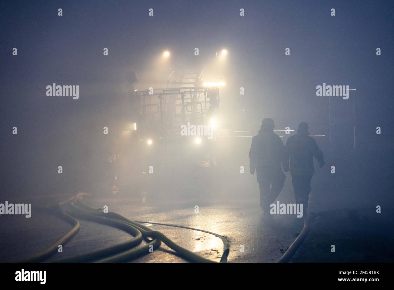 Wehr, Germany. 30th Dec, 2022. Firefighters walk through a mixture of ...