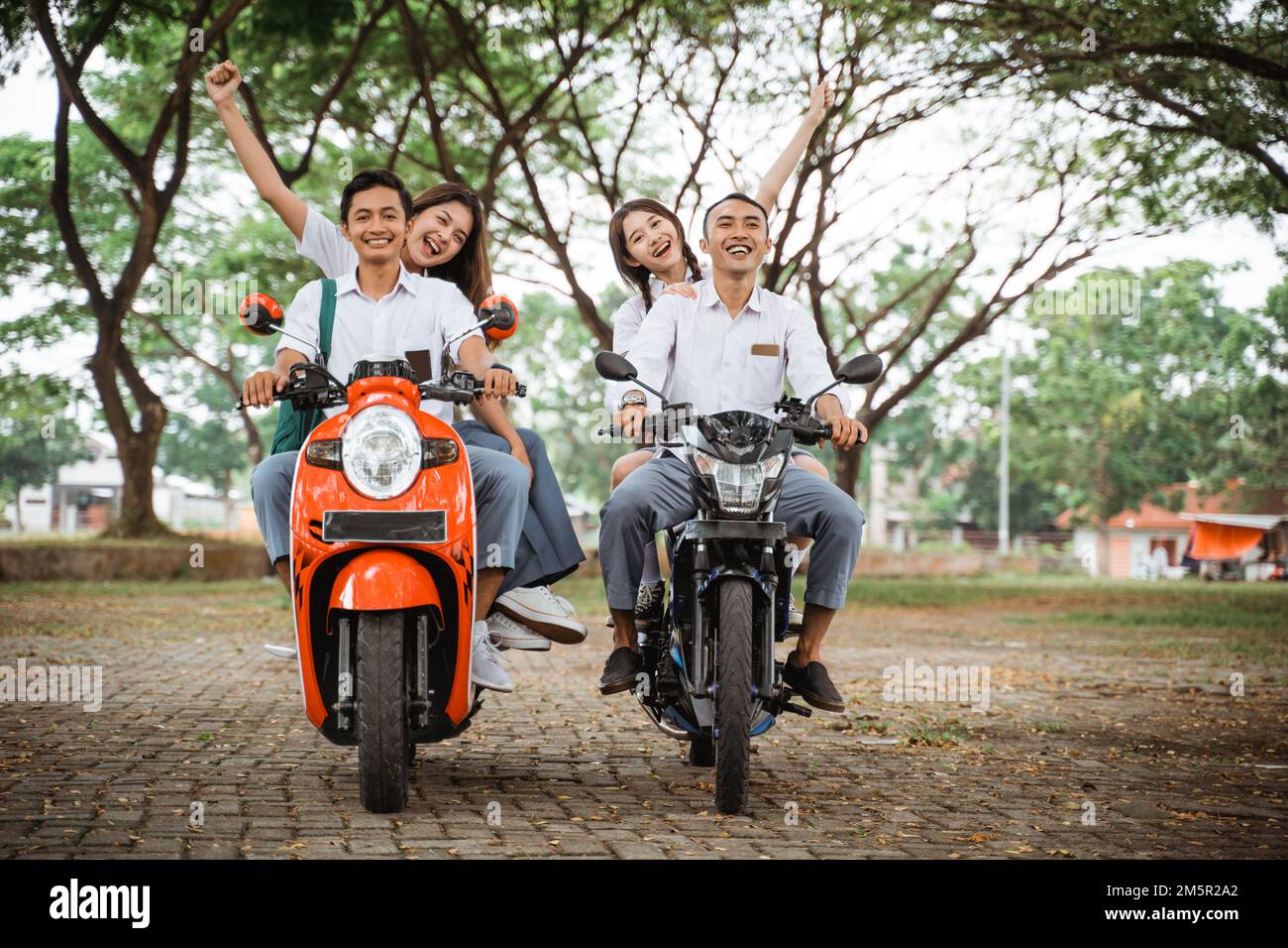 group of high school students celebrating graduation by motorbike Stock ...