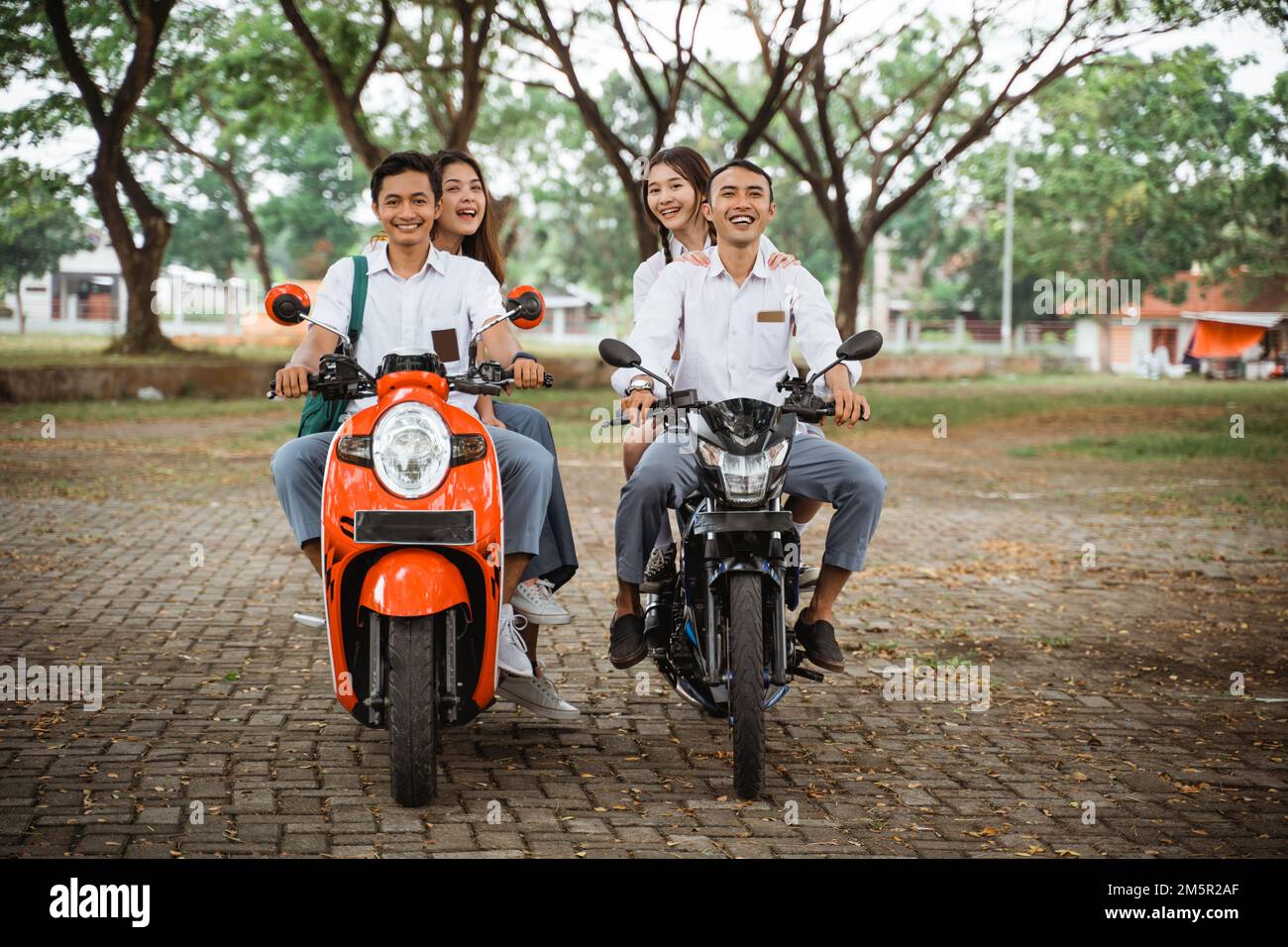 group of high school students riding motorcycle without a helmet Stock ...